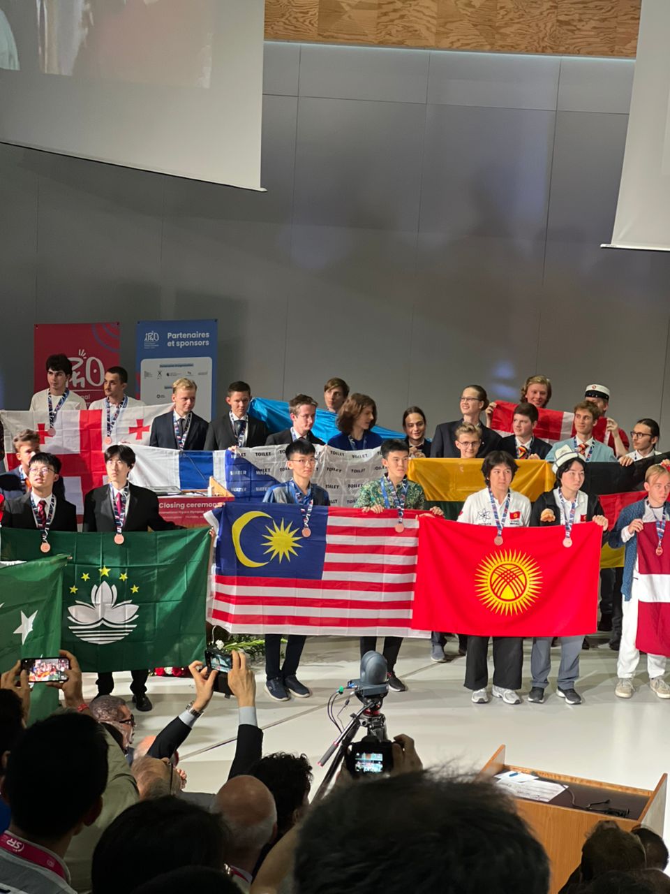 A group of people holding flagsDescription automatically generated